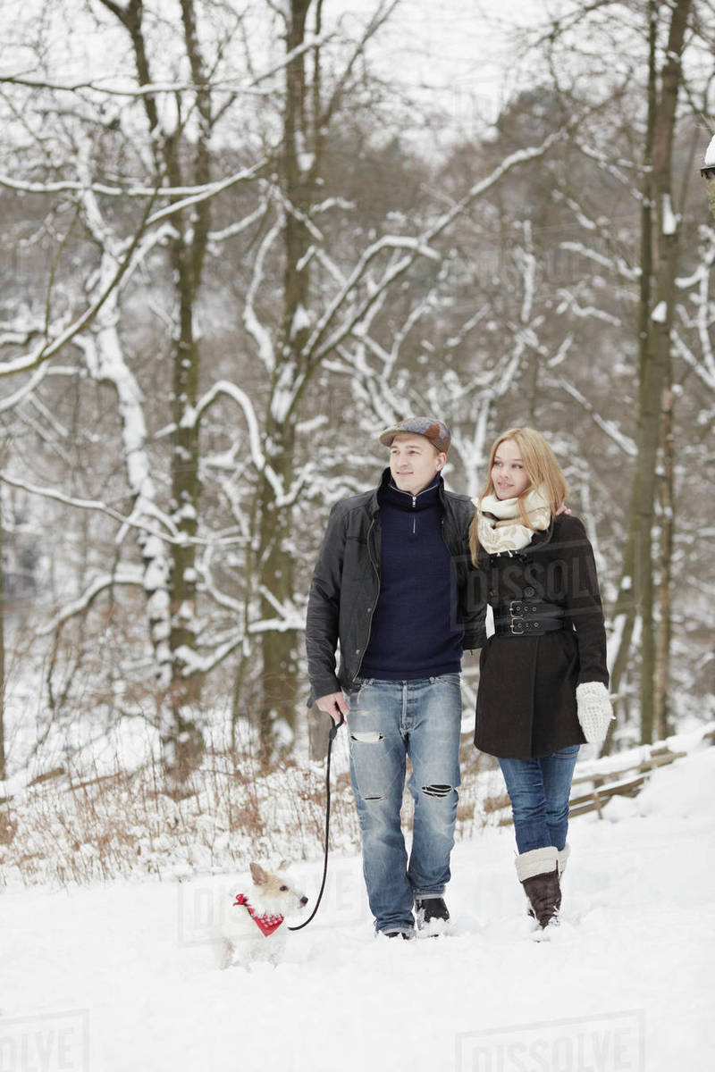 Young couple walking dog - Royalty-free Stock Photo | Dissolve