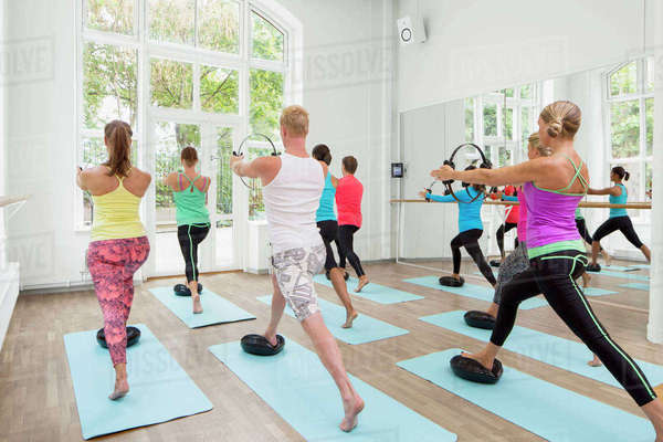 Group of people exercising in fitness class - Stock Photo - Dissolve