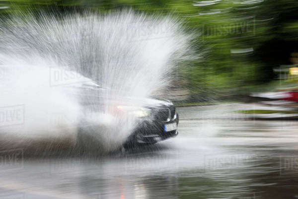 Car splashing water on road - Royalty-free Stock Photo | Dissolve