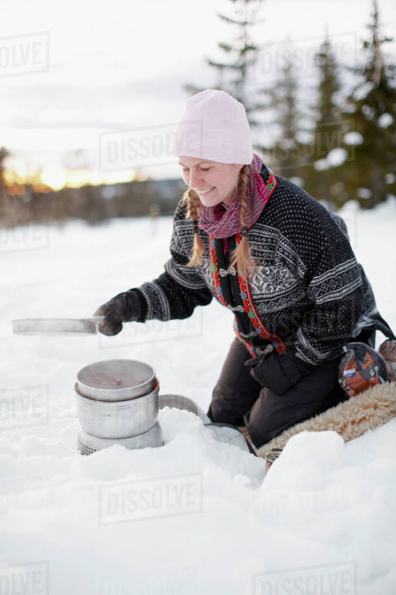 Woman cooking on snow - Stock Photo - Dissolve