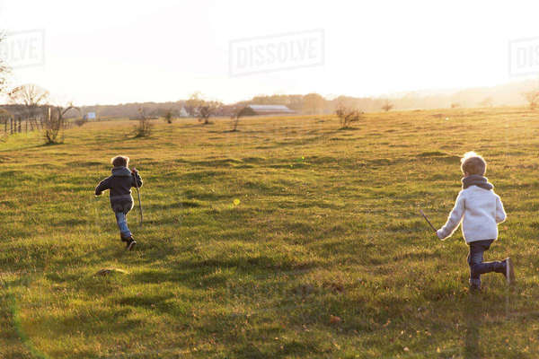 Boys running through meadow - Royalty-free Stock Photo | Dissolve