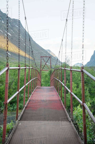 Hanging footbridge in mountains - Stock Photo - Dissolve