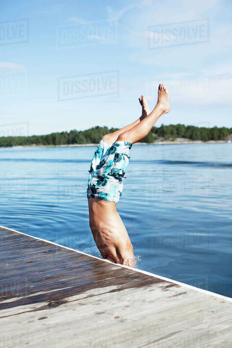 Teenage boy jumping into water - Royalty-free Stock Photo | Dissolve