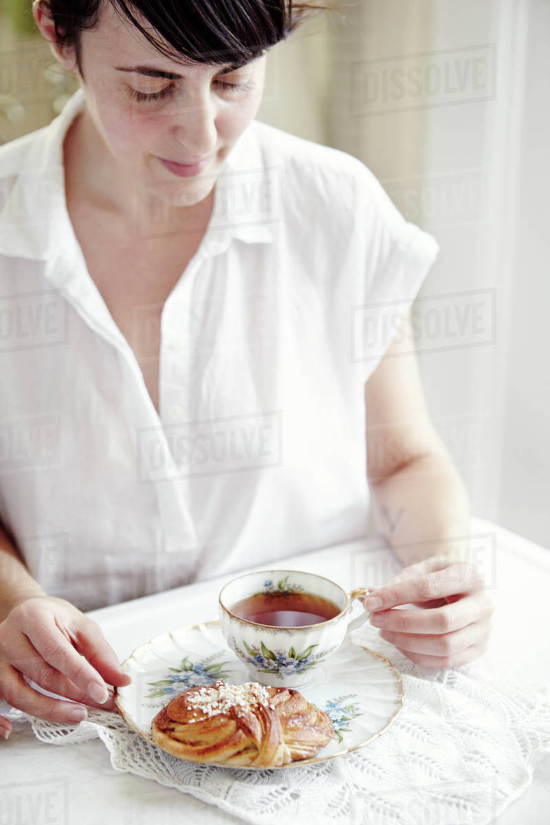 Young woman having tea - Royalty-free Stock Photo | Dissolve