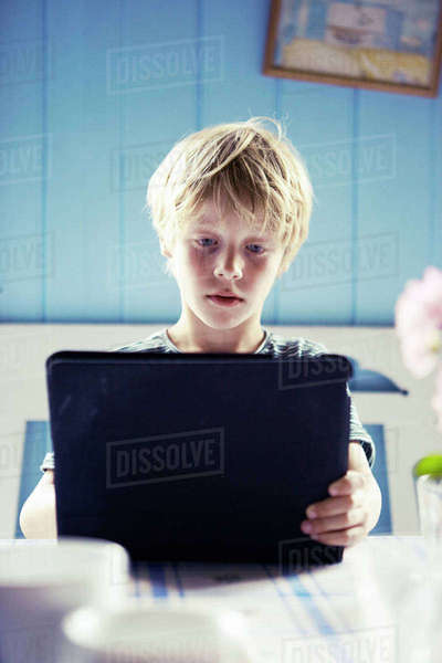 Boy using digital tablet - Stock Photo - Dissolve