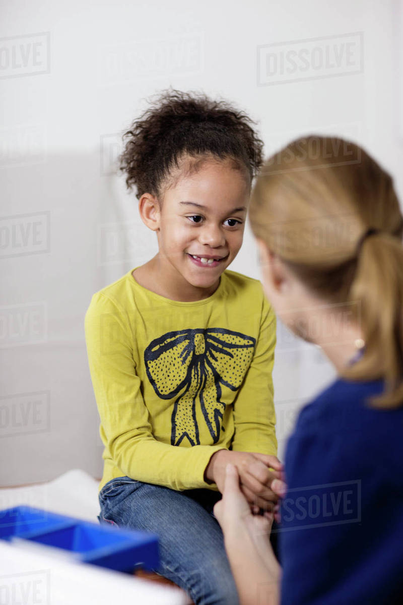 Doctor checking girls hand - Stock Photo - Dissolve