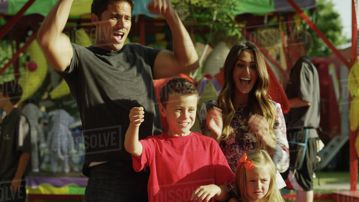 Happy cheering family winning amusement park fun fair game - Royalty ...