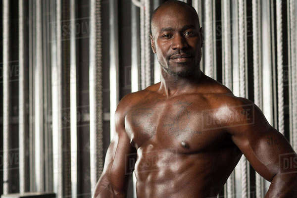 Proud bodybuilder flexing muscles backstage in preparation for ...