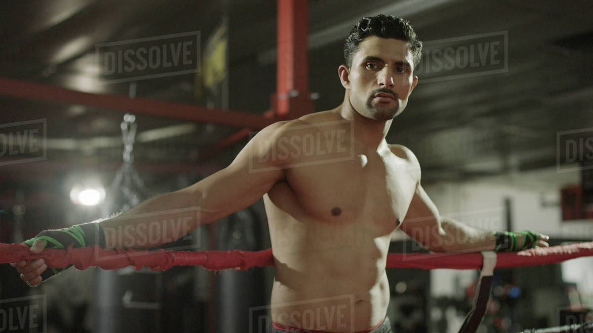 Portrait of serious boxer standing in boxing ring - Stock Photo - Dissolve