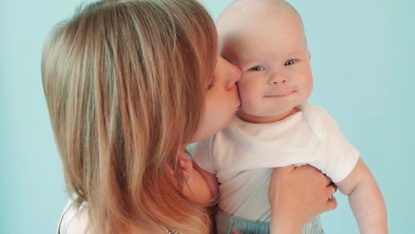 Mother kissing a baby on the cheek kindly in slow motion. - HD Royalty ...