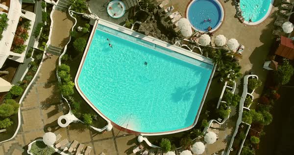 Aerial of pool in hotel with people swimming in it. - 4K Royalty-free ...