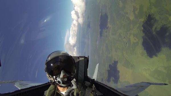 A pilot or passenger is shown flying in a F18 fighter plane, the clouds ...