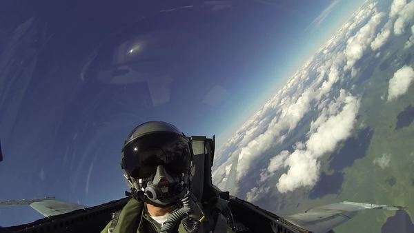 A pilot or passenger is shown flying in a F18 fighter plane, the clouds ...