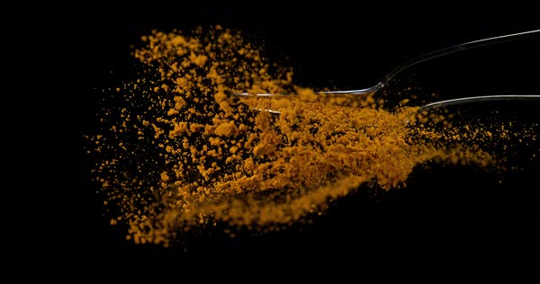 Spoon and curry powder falling against black background - Stock Video ...