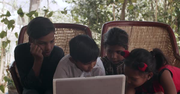 Indian children working sharing together as teamwork on a laptop ...
