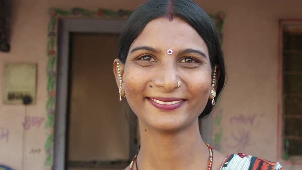 Close up of beautiful Indian lady in traditional dress looks and points ...
