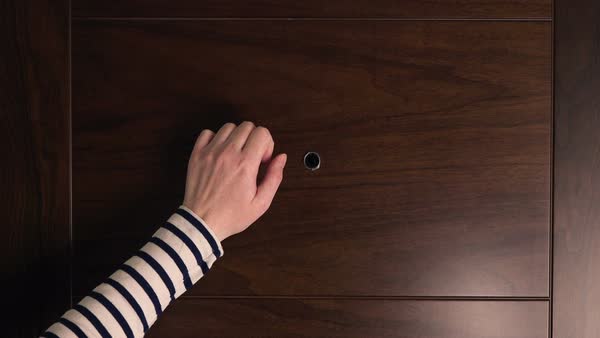 Female hand knocking at wooden door, visitor or guest at the door ...