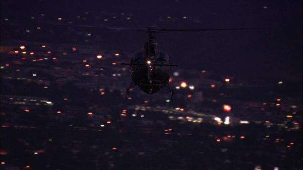 Handheld wide shot of a helicopter flying over a city at night - HD ...