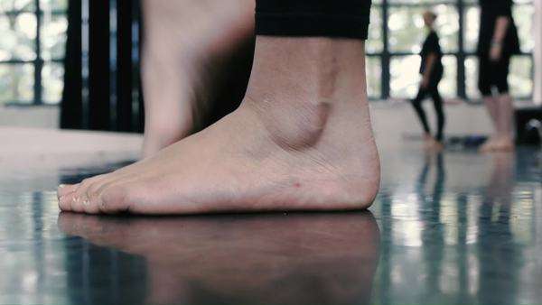 Three barefoot young girls having a ballet lesson in a dance studio at ...