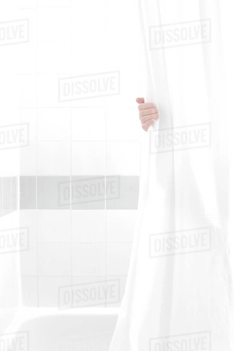 Hand Pulling Back Shower Curtain - Stock Photo - Dissolve