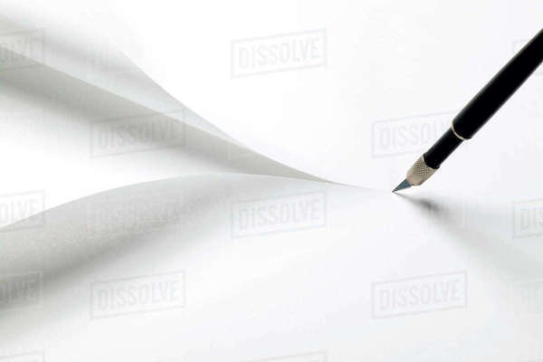 Knife Cutting Through Paper - Stock Photo - Dissolve