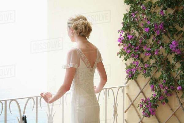 A Woman In A White Dress Looking Out Over A Balcony - Royalty-free ...