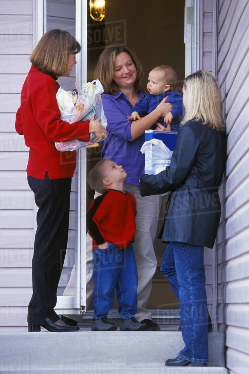 Women Talking To Mother At Front Door - Stock Photo - Dissolve