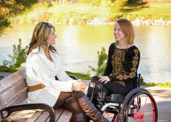 Young paraplegic woman and her friend spending quality time together in ...