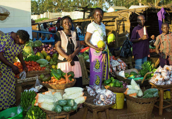 Agriculture - African street traders in a market stall selling fruit ...