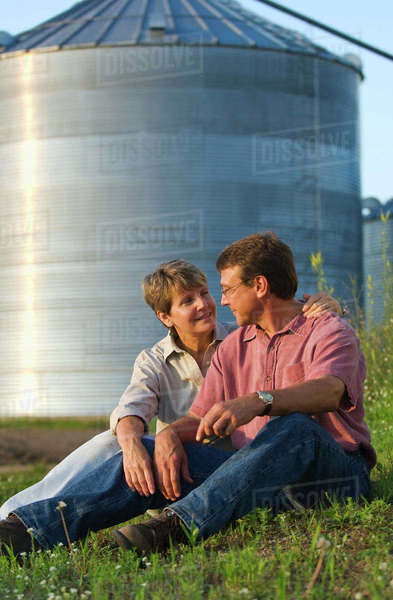 Agriculture - Husband and wife farmers sit together while sharing some ...