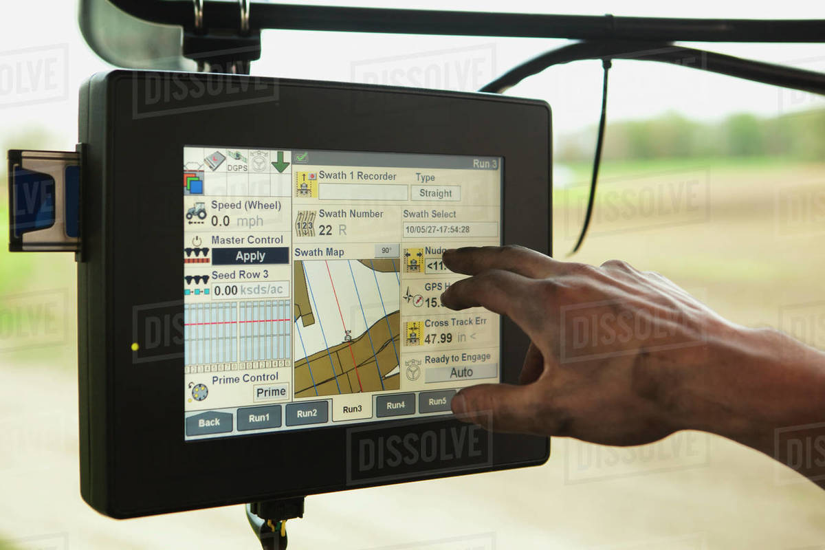 Agriculture - A farmer uses a touch screen computer mounted in his ...