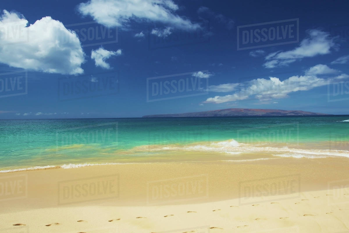 Waves of the pacific ocean rolling onto a white sand beach of an ...