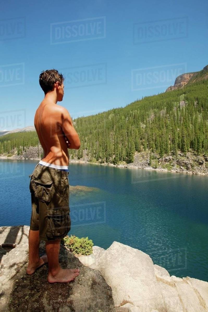Young Man Looking Out From Cliff - Royalty-free Stock Photo | Dissolve