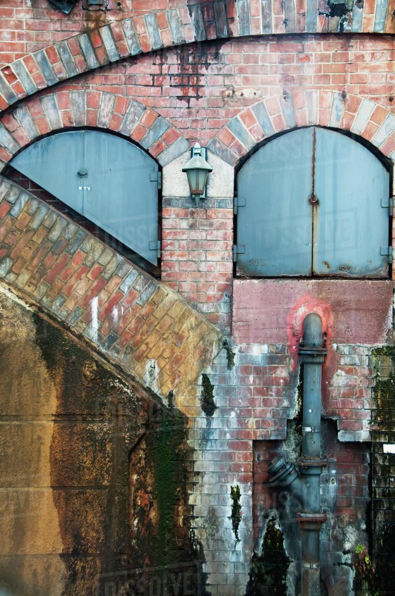 Exterior of a brick building that is weathered and has bad water damage ...