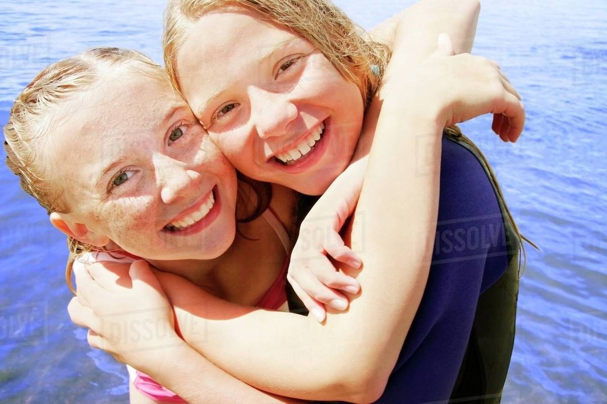 Two Girls Hug In The Water - Stock Photo - Dissolve