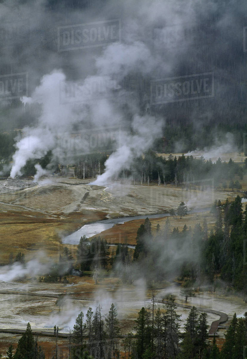 Steam rises from geothermal hot springs and geysers in Yellowstone ...