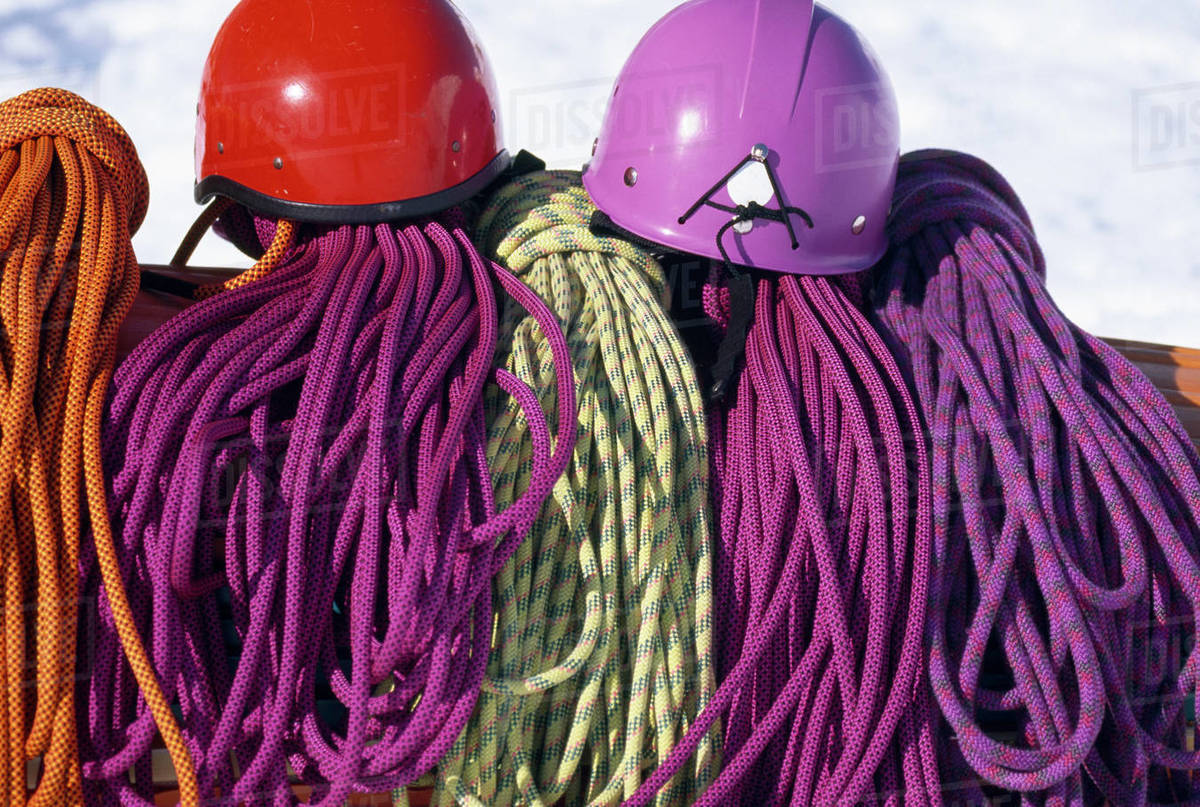 Brightly coloured climbing helmets and ropes at a base camp in Denali ...