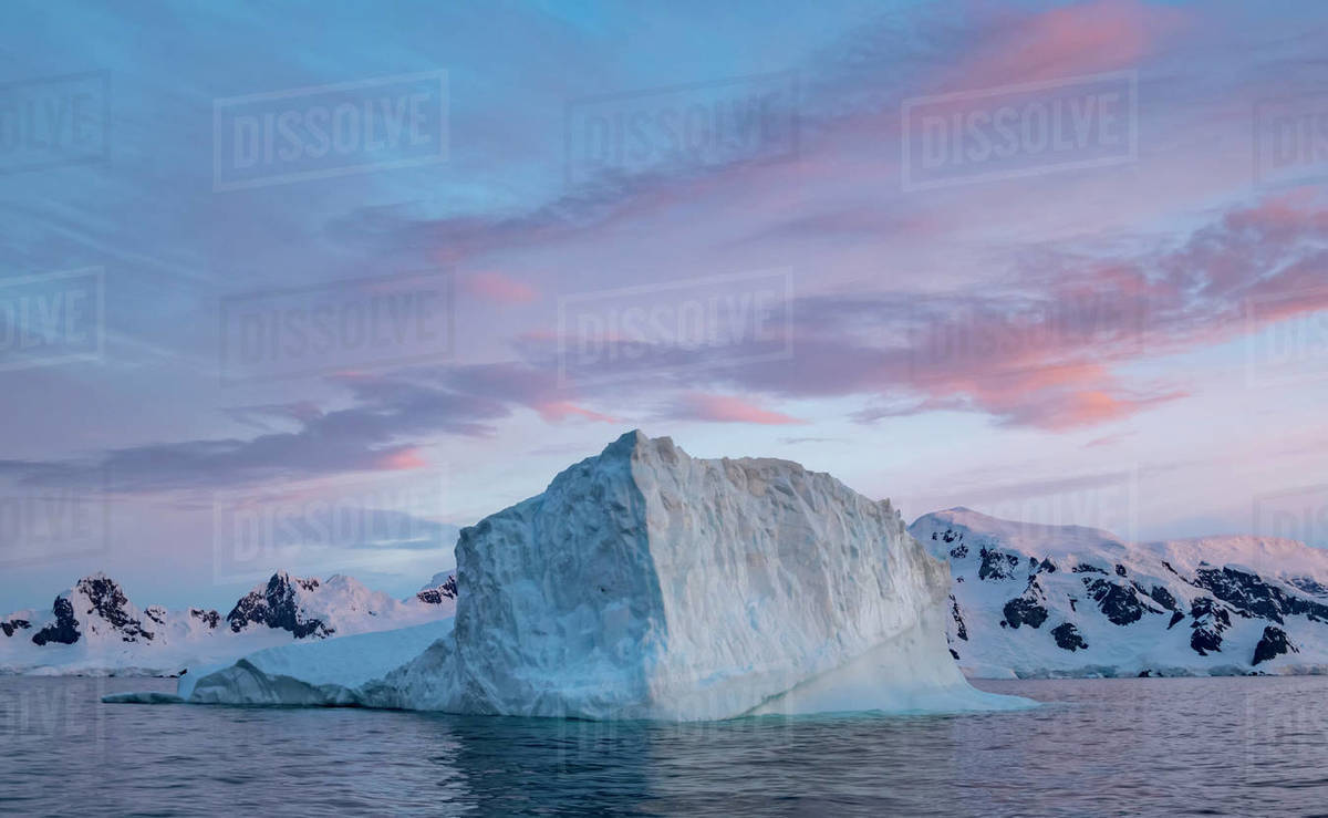 Iceberg and sunset sky around midnight in the antarctic summer ...