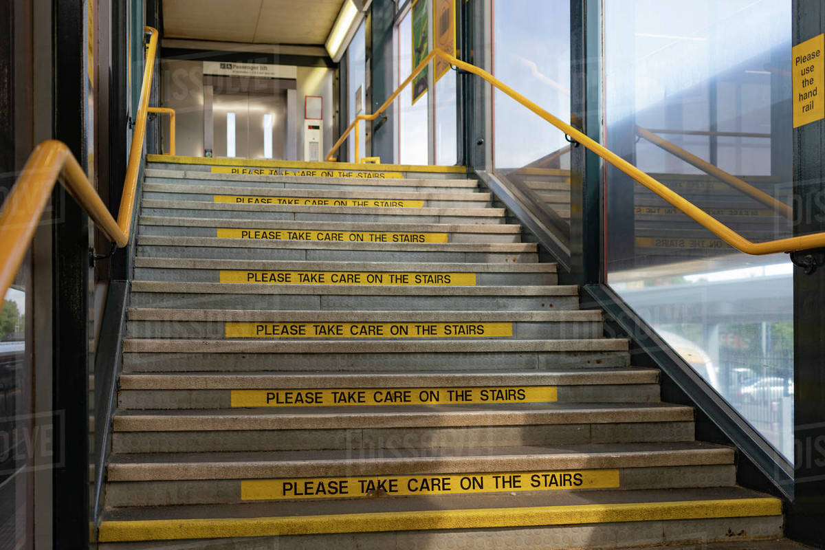 Yellow markings warning to take caution on the stairs in a train ...