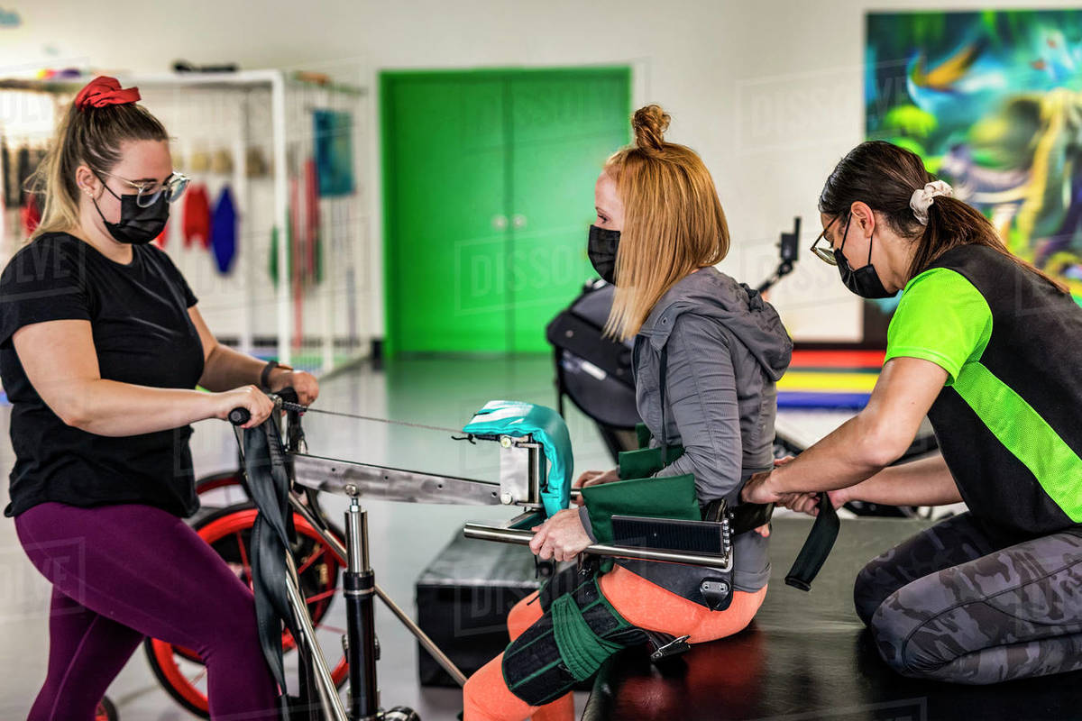 A paraplegic woman working out using an assisted walking machine with ...