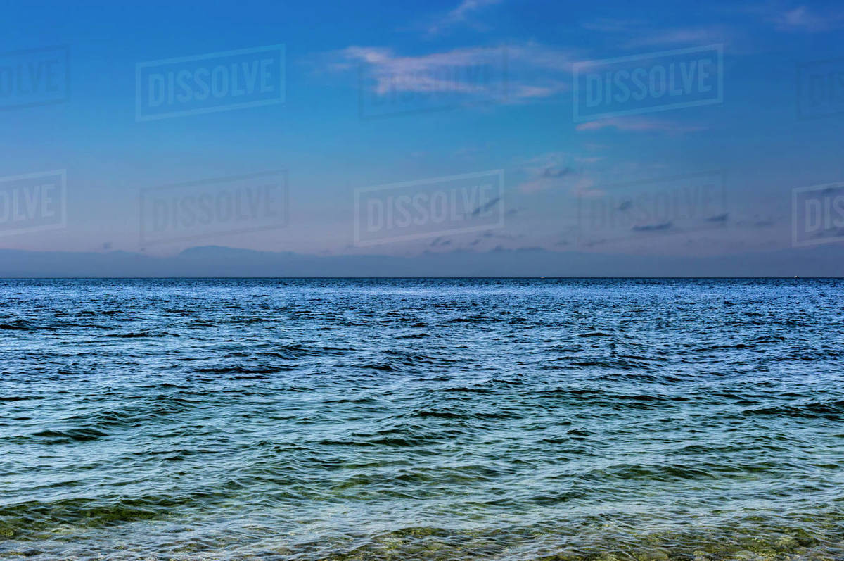 Vibrant blue water of the Pacific Ocean at sunset; British Columbia ...