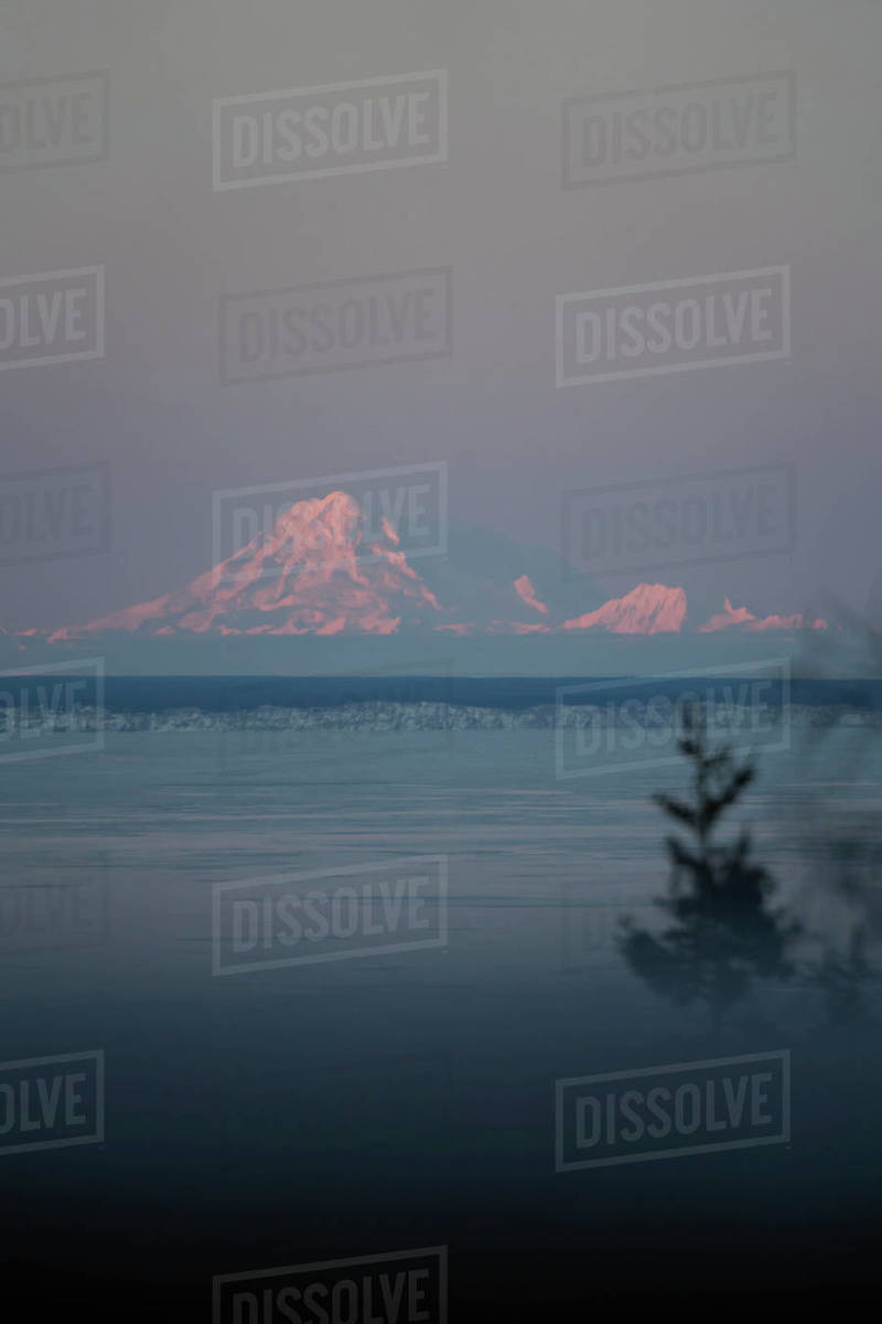 The volcano Mt Redoubt towers above Cook Inlet, near Anchorage Alaska ...