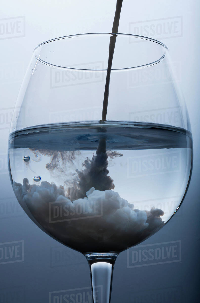 A Dark Cloudy Liquid Being Poured Into A Water Glass; Tarifa, Cadiz ...