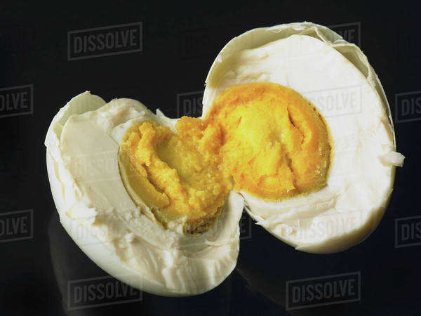 An open egg on a black background - Stock Photo - Dissolve
