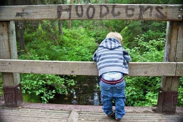 Young Boy Looking Over A Bridge With His Pants Falling Down And The ...