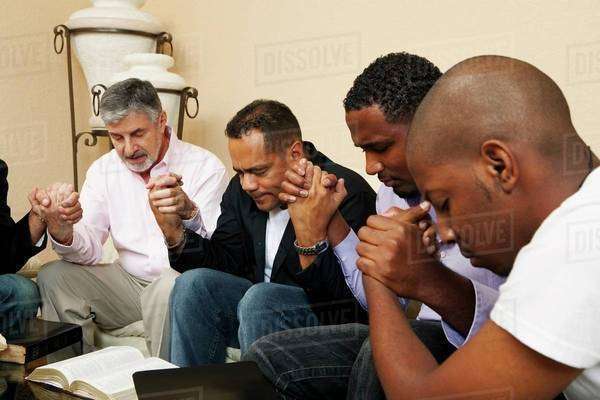 A Group Of Men Praying Together With An Open Bible - Royalty-free Stock ...
