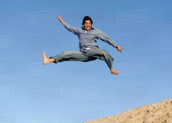 A Man Jumping Into The Air - Stock Photo - Dissolve