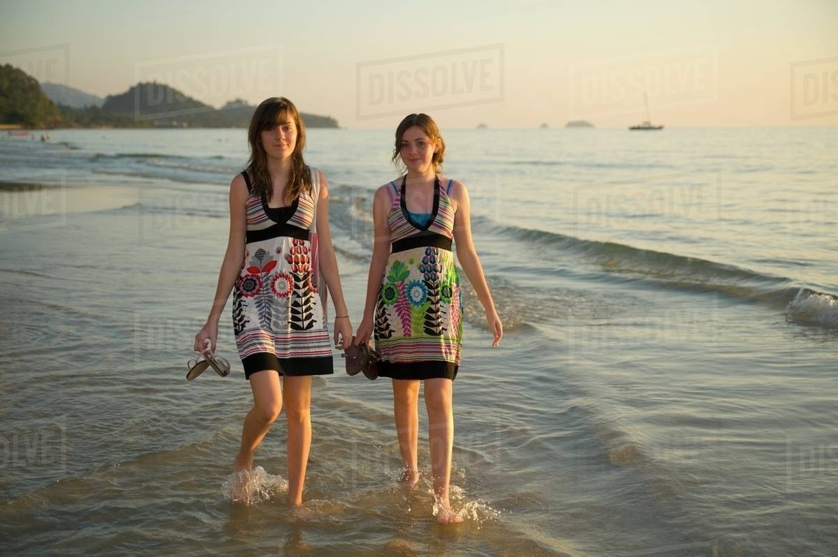 Koh Chang, Thailand; Two Girls Walking Barefoot In The Shallow Water ...