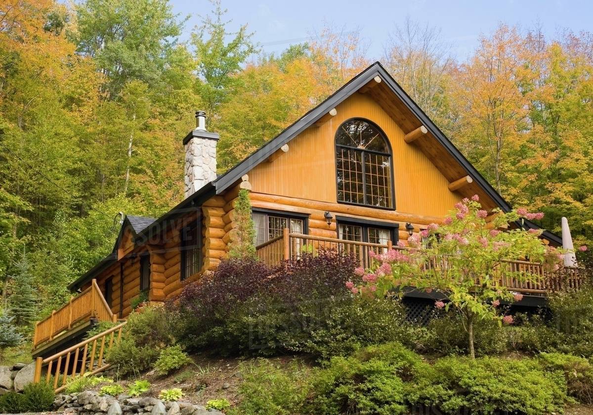 A Log House Surrounded By Trees In Autumn; Quebec, Canada - Royalty ...