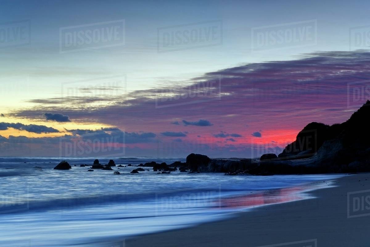 Sunset Over Water And A Beach - Royalty-free Stock Photo | Dissolve